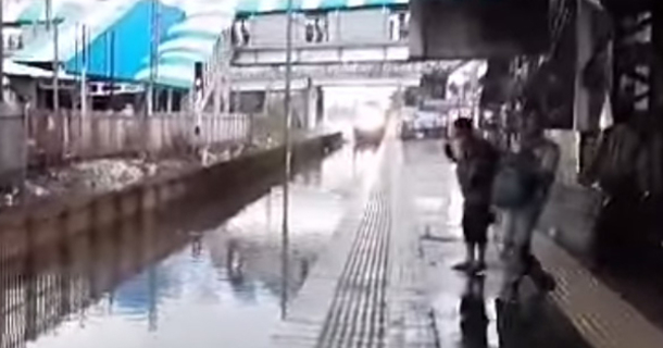 Train enters flooded station, pedestrians are then covered with huge ...